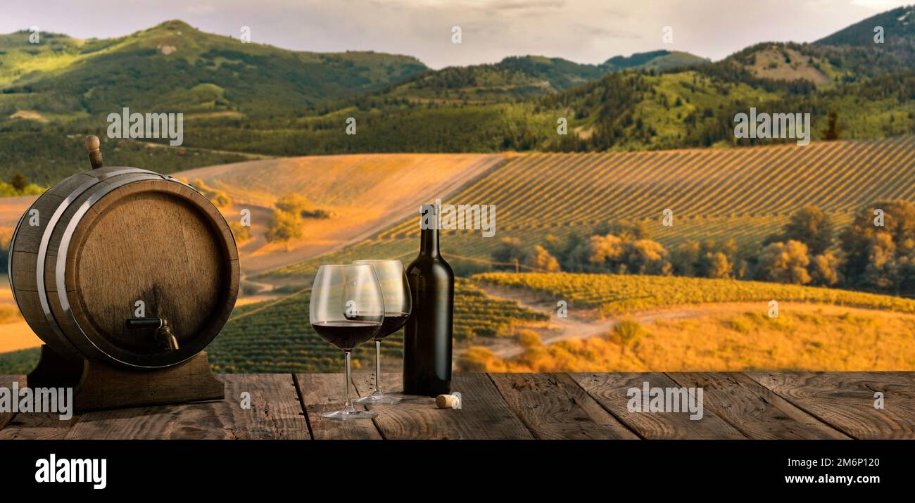 Decanter, two glasses with red wine and wooden barrel standing on ...