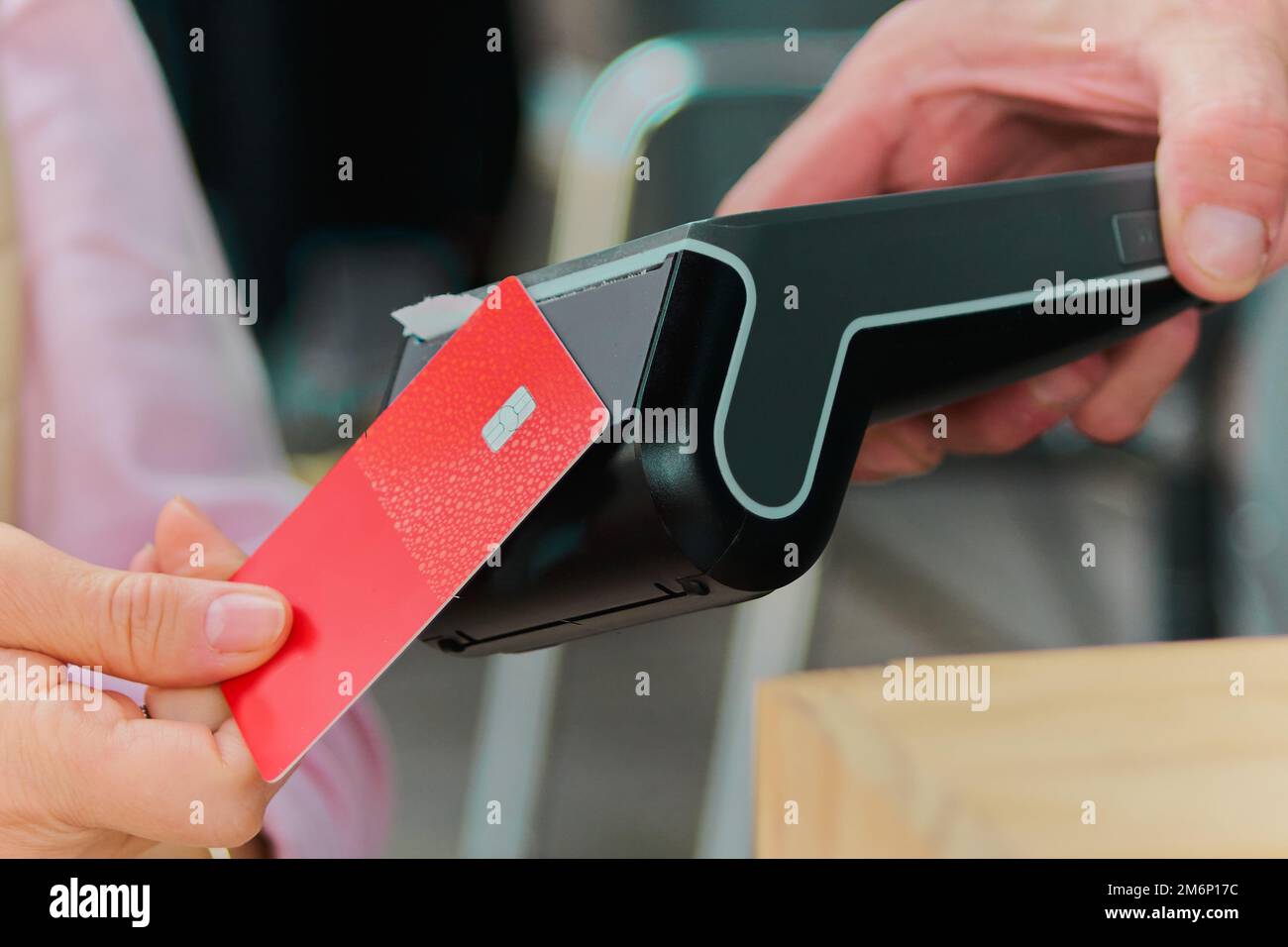 Woman paying for a purchase with a grown-up card at a wireless ...