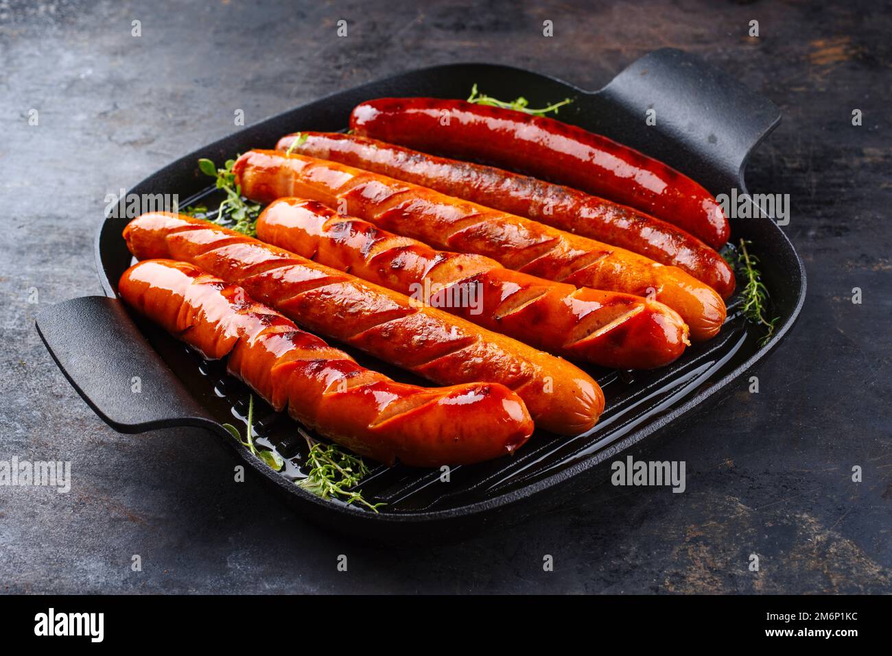 Traditional German barbecue Bratwurst sausages served in a rustic cast ...