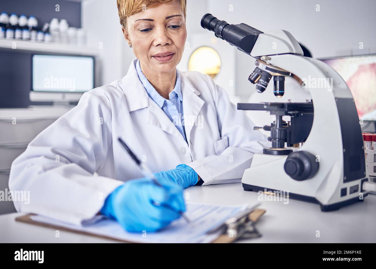 Senior black woman, research or scientist writing a science report in a ...