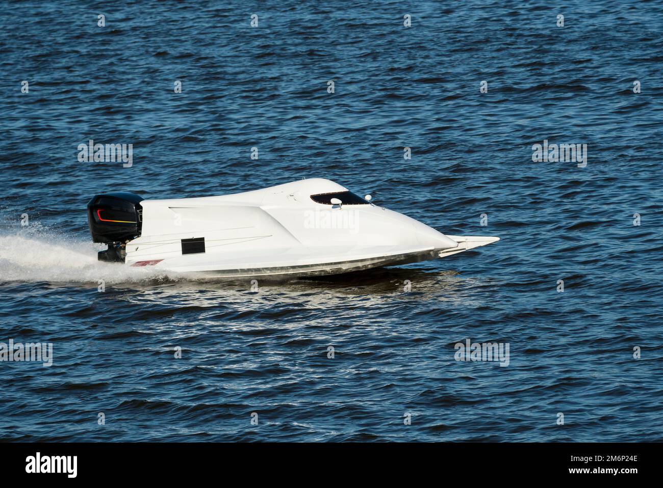 White racing powerboat go fast along the blue water Stock Photo - Alamy