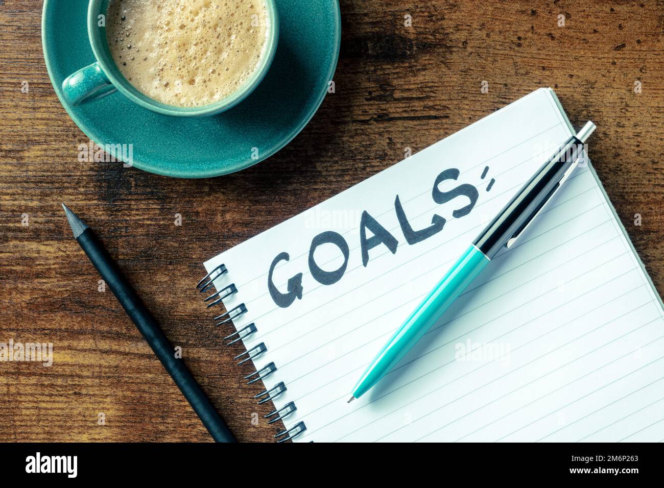 Goal setting. A notebook with the handwritten word Goals, with coffee ...