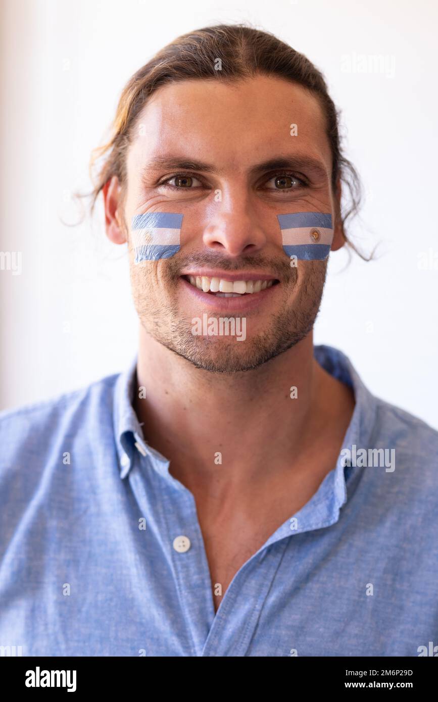Vertical image of happy caucasian man with flags of argentina on face ...
