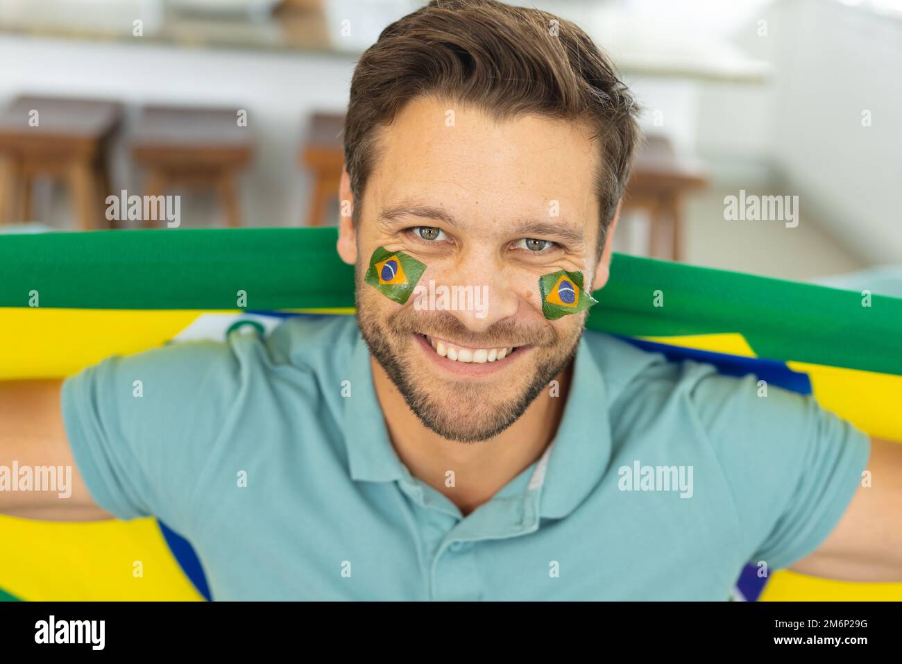 Image of happy caucasian man with flags of brazil on face over flag of ...