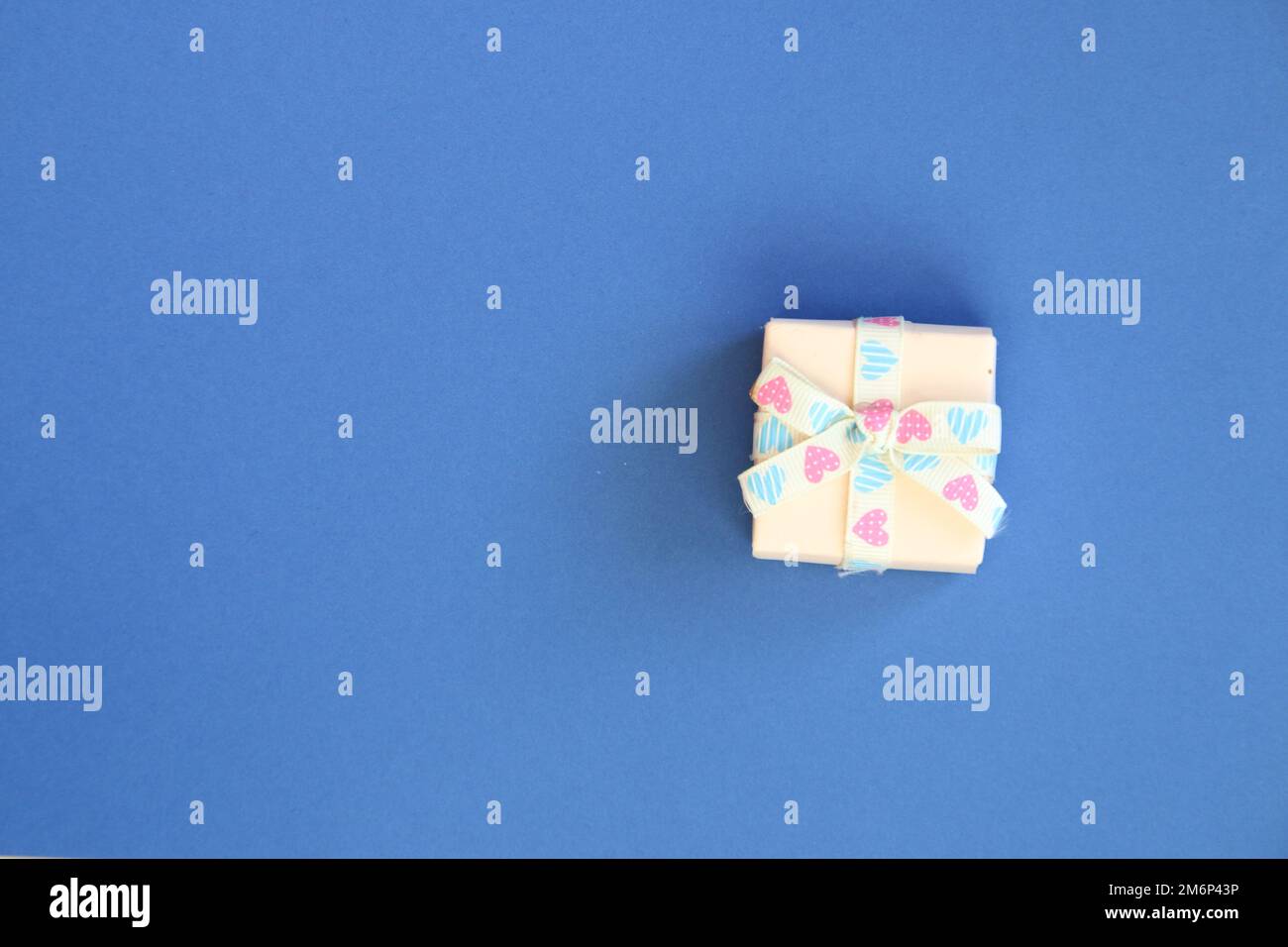 Holiday gift box or present with bow ribbon on a blue background Stock ...