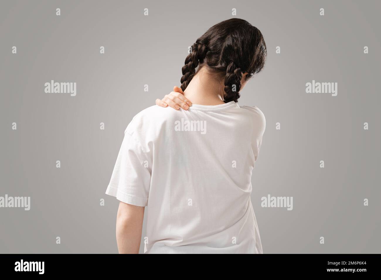 Arthritis and chondrosis. A young woman holds her shoulder with her ...