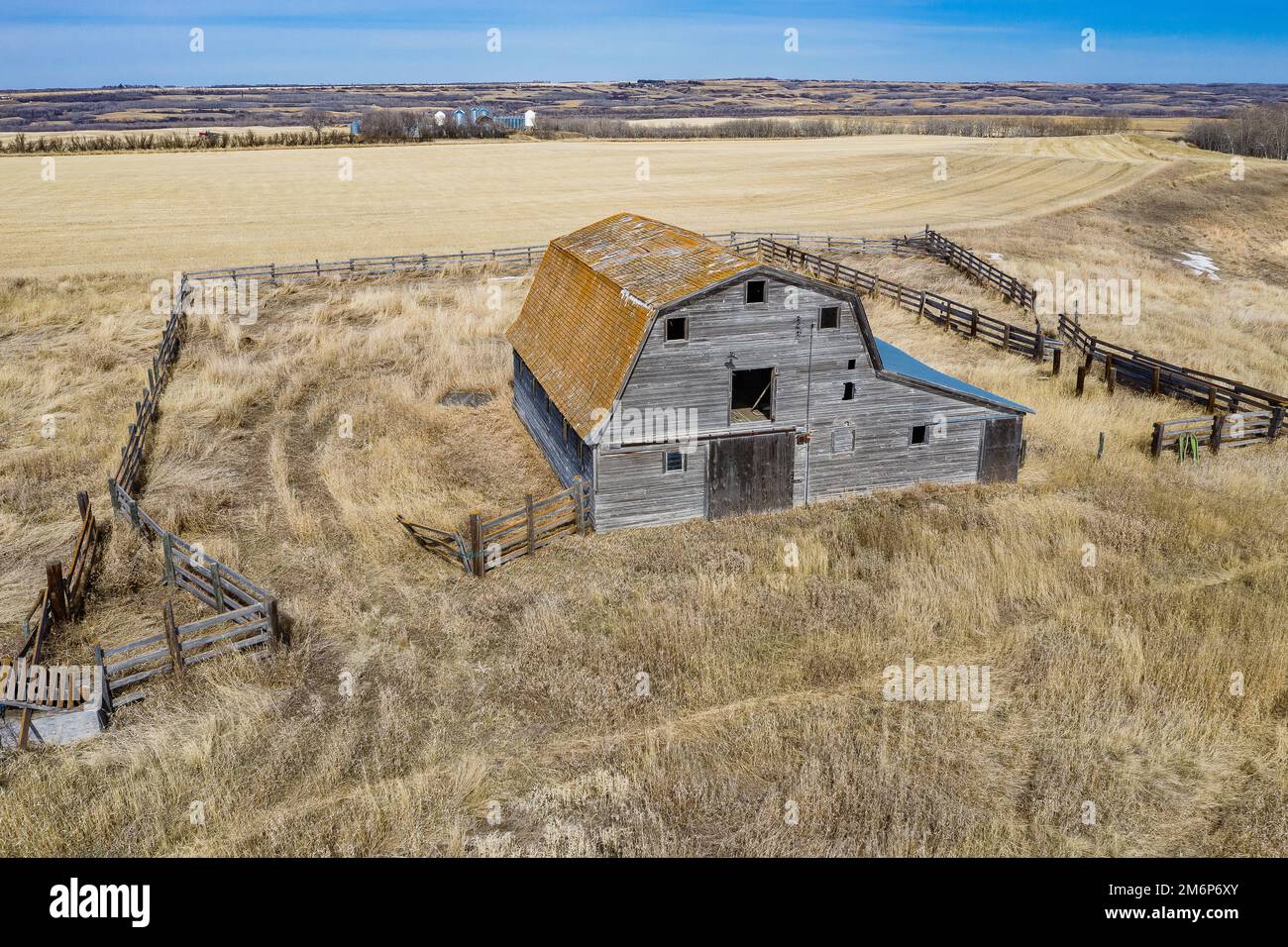 An aerial shot of an old wooden barn with a field in the background in ...