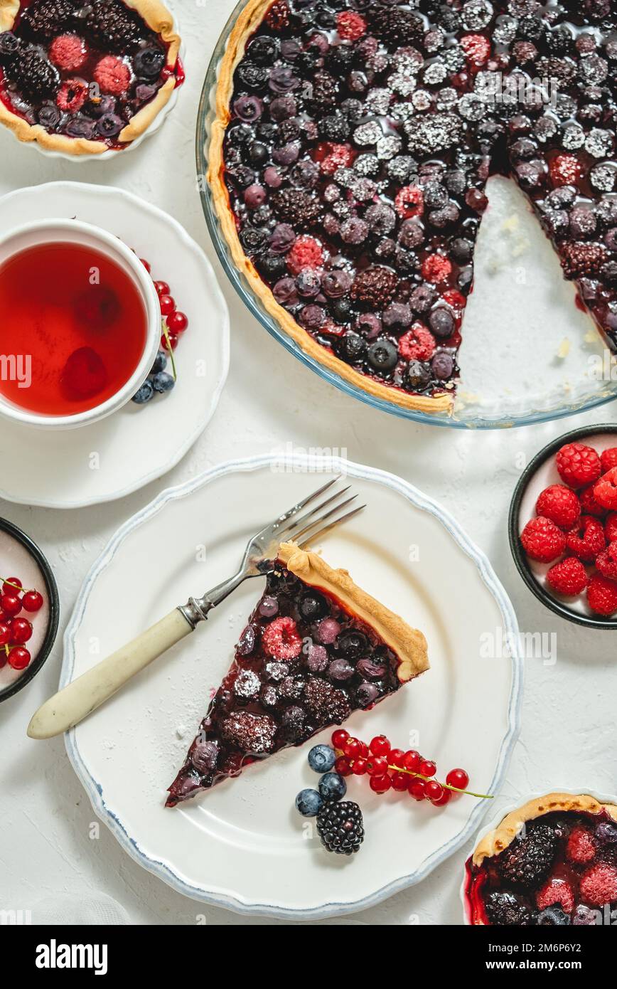 Delicious homemade piece on a plate and the whole homemade forest berry ...