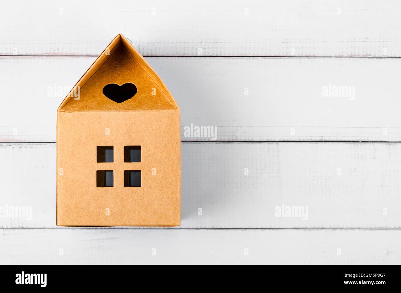 Brown paper house origami on wooden background with empty space for ...