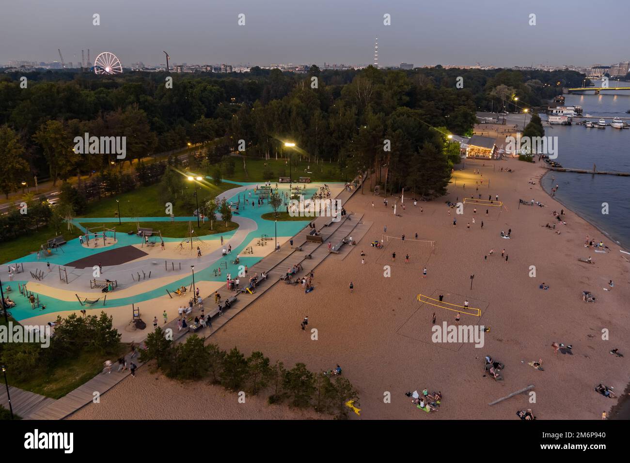 Illuminated outdoor sports ground on Krestovsky Island at dusk, public ...
