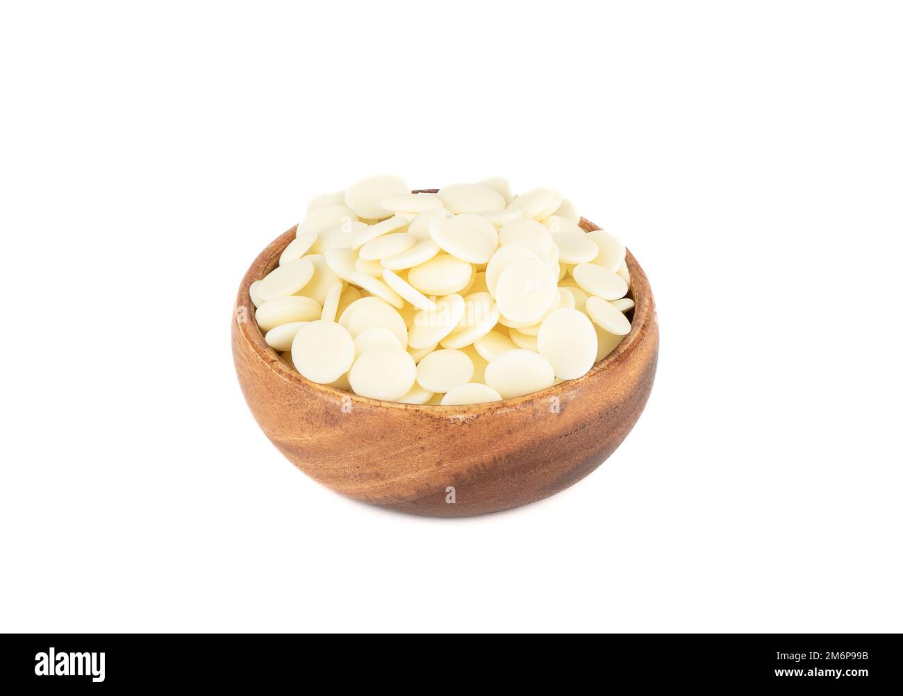 Culinary icing in the form of milk chocolate drops in a bowl over a ...