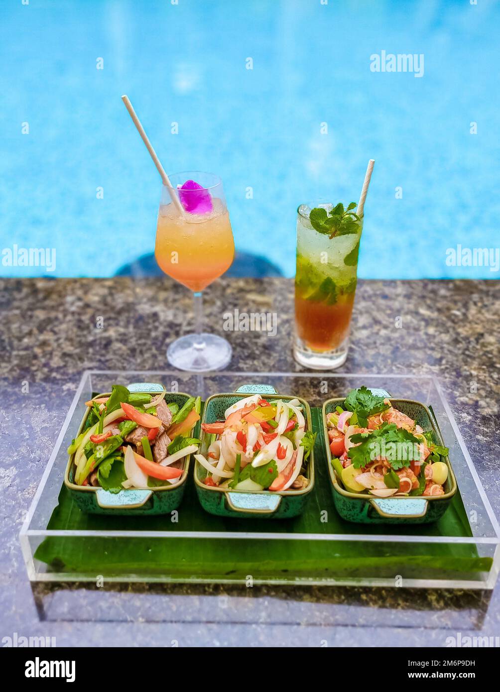 Orange cocktail and mojito at a swimming pool on a luxury vacation in ...