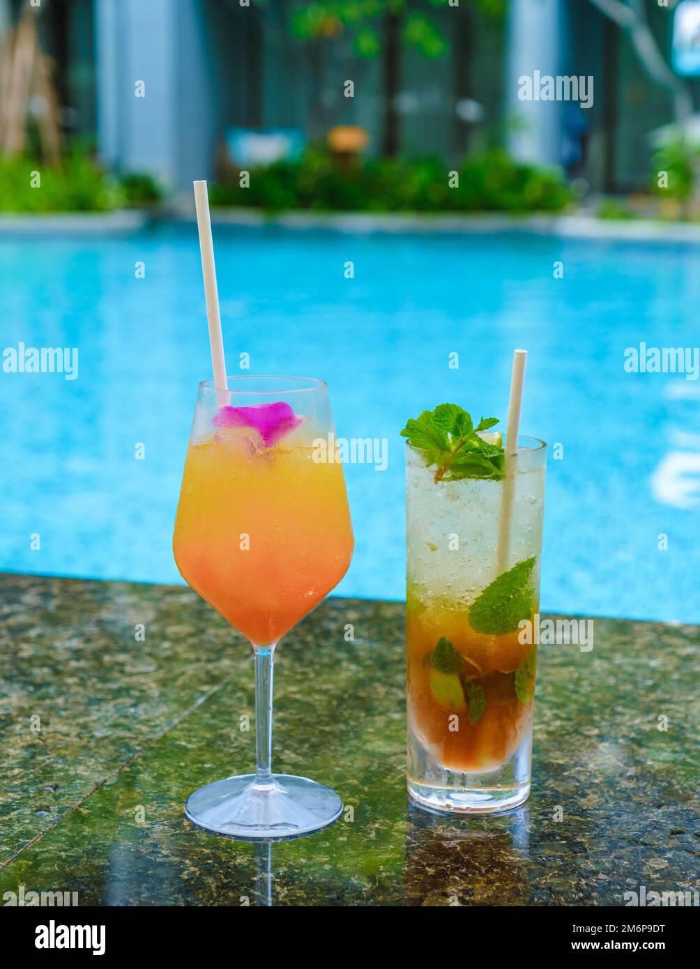 Orange cocktail and mojito at a swimming pool on a luxury vacation ...