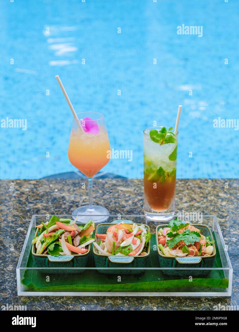 Orange cocktail and mojito at a swimming pool on a luxury vacation in ...