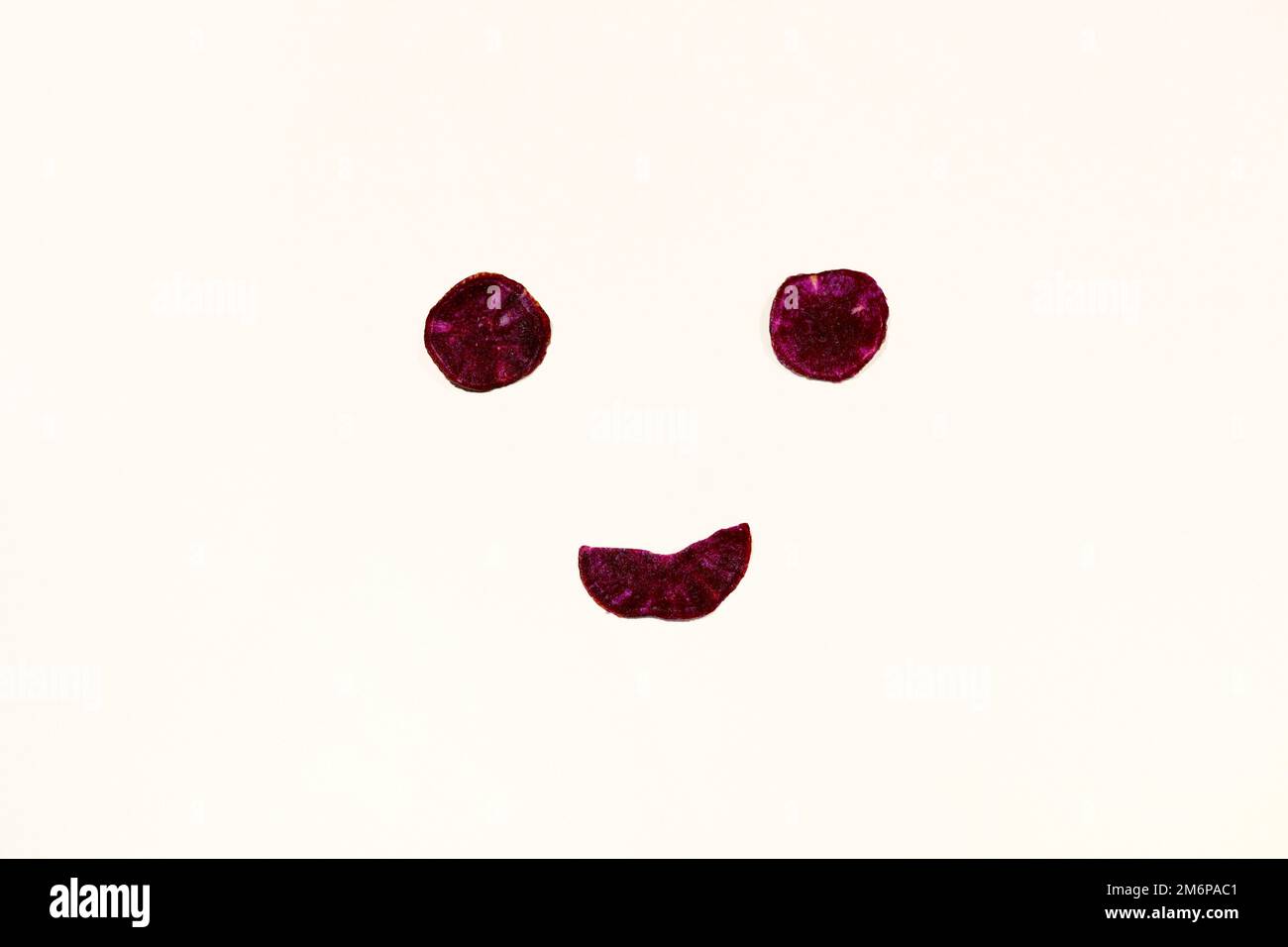 Smile face with dried purple sweet potatoes on the white background ...