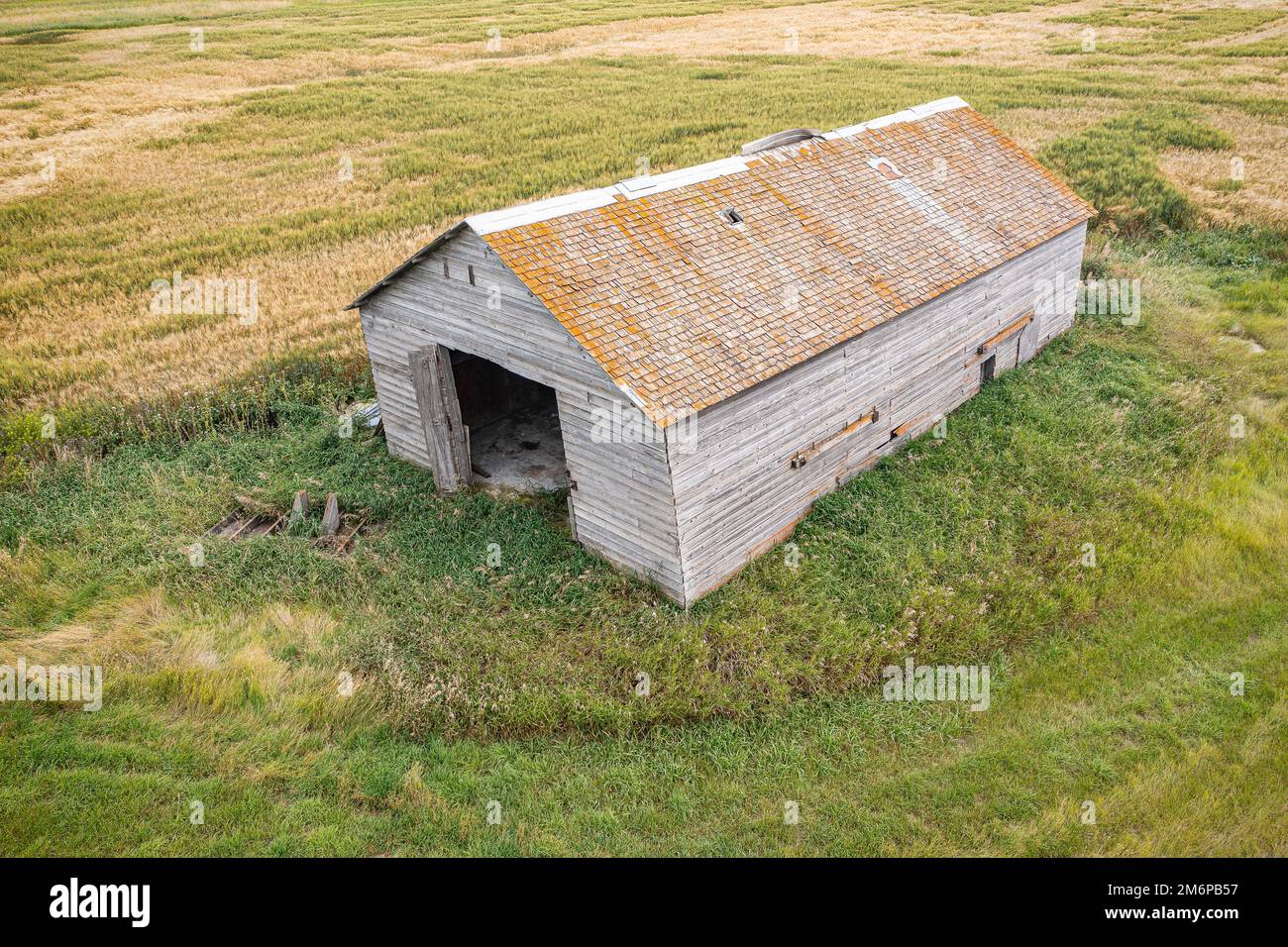 An aerial of an old abandoned wooden homestead in Canadian prairies ...