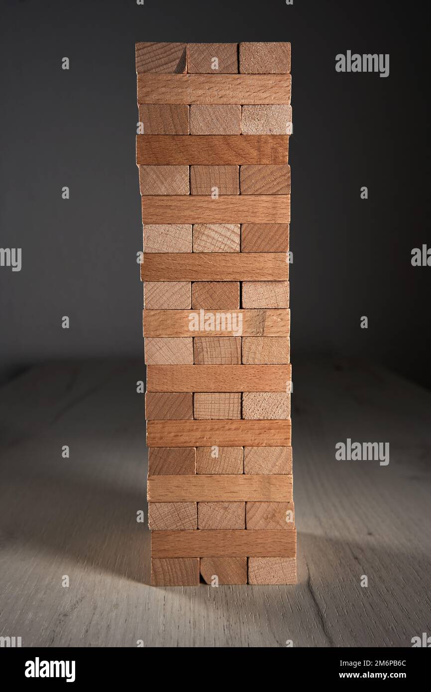 A stack of wooden blocks in a game of Jenga on a table Stock Photo - Alamy