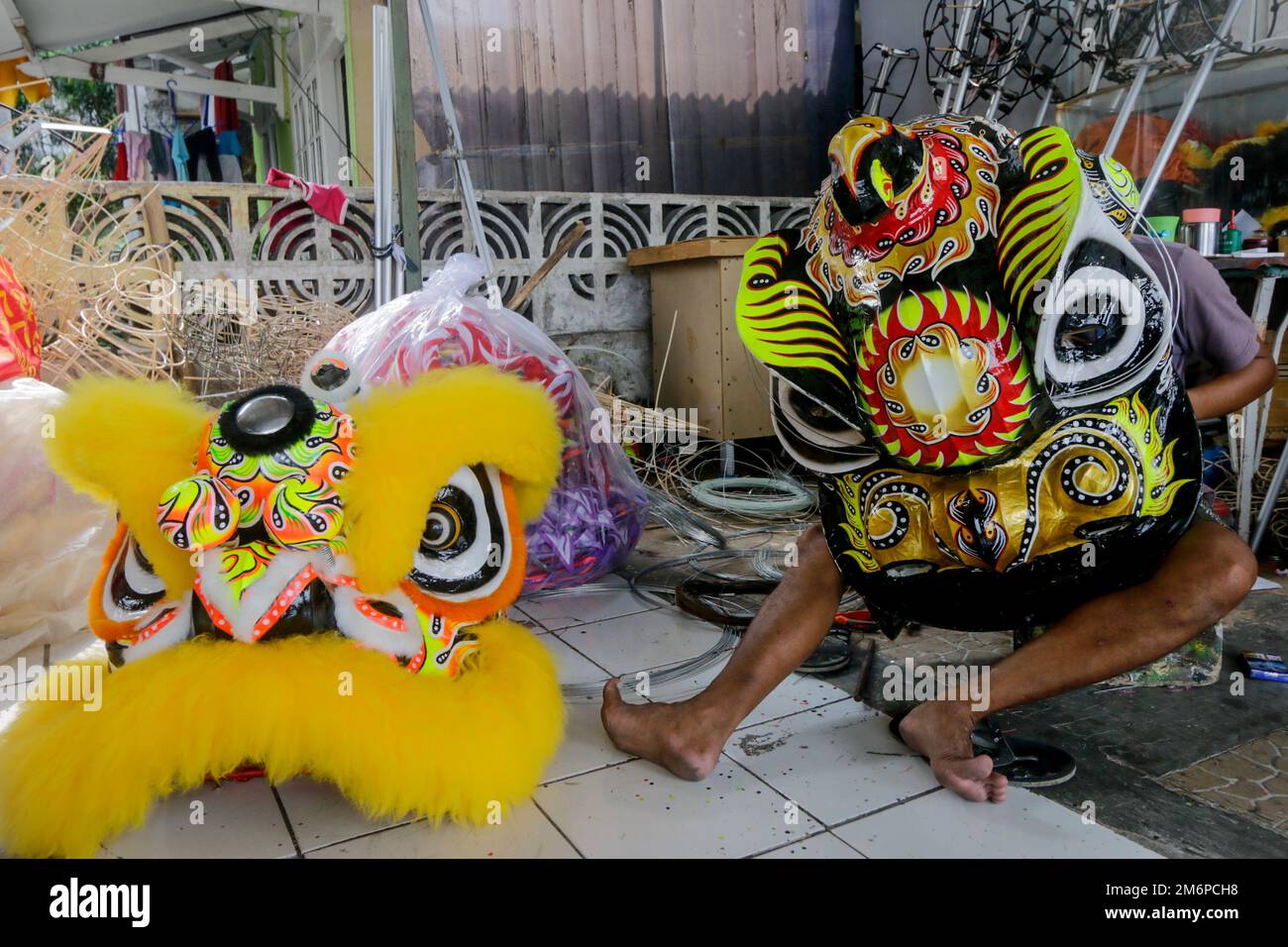A craftsman produces parts of a lion dance costume ordered by customers ...