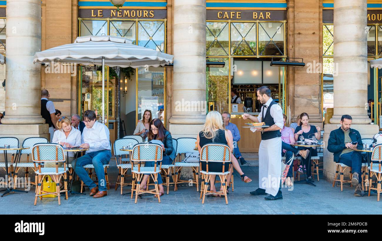 Paris France people drinking coffee on the terrace of a cafe restaurant ...