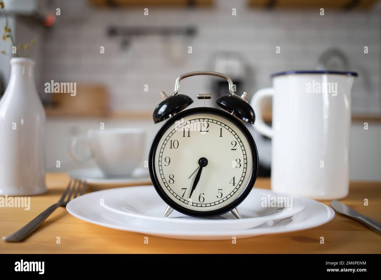 Intermittent fasting concept alarm clock on kitchen table Stock Photo ...
