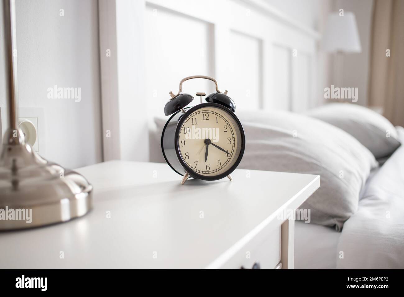 Vintage alarm clock in bright bedroom Stock Photo - Alamy