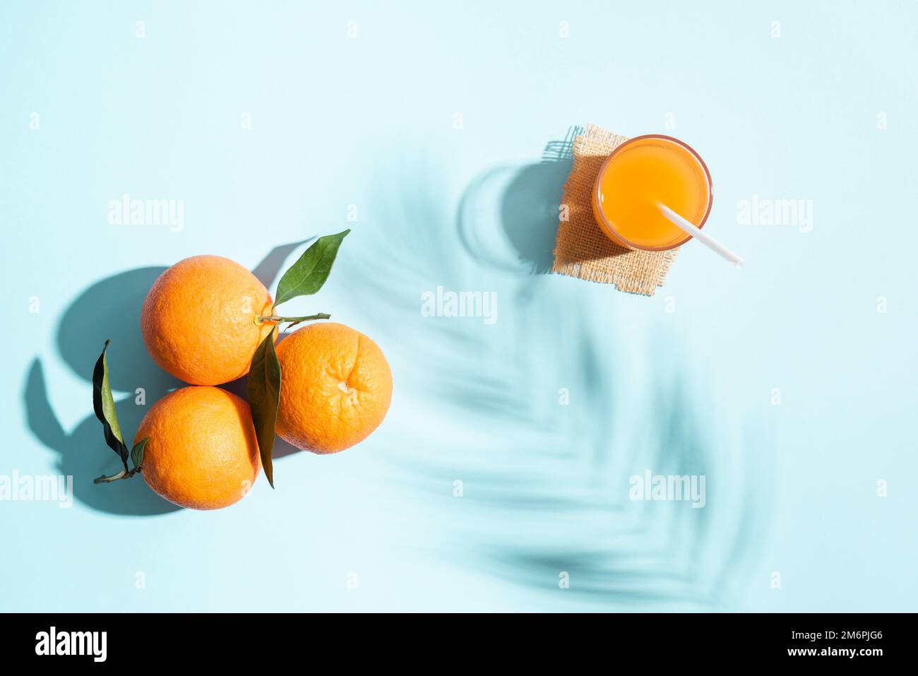 Orange fruit top view with glass of juice on blue background with ...