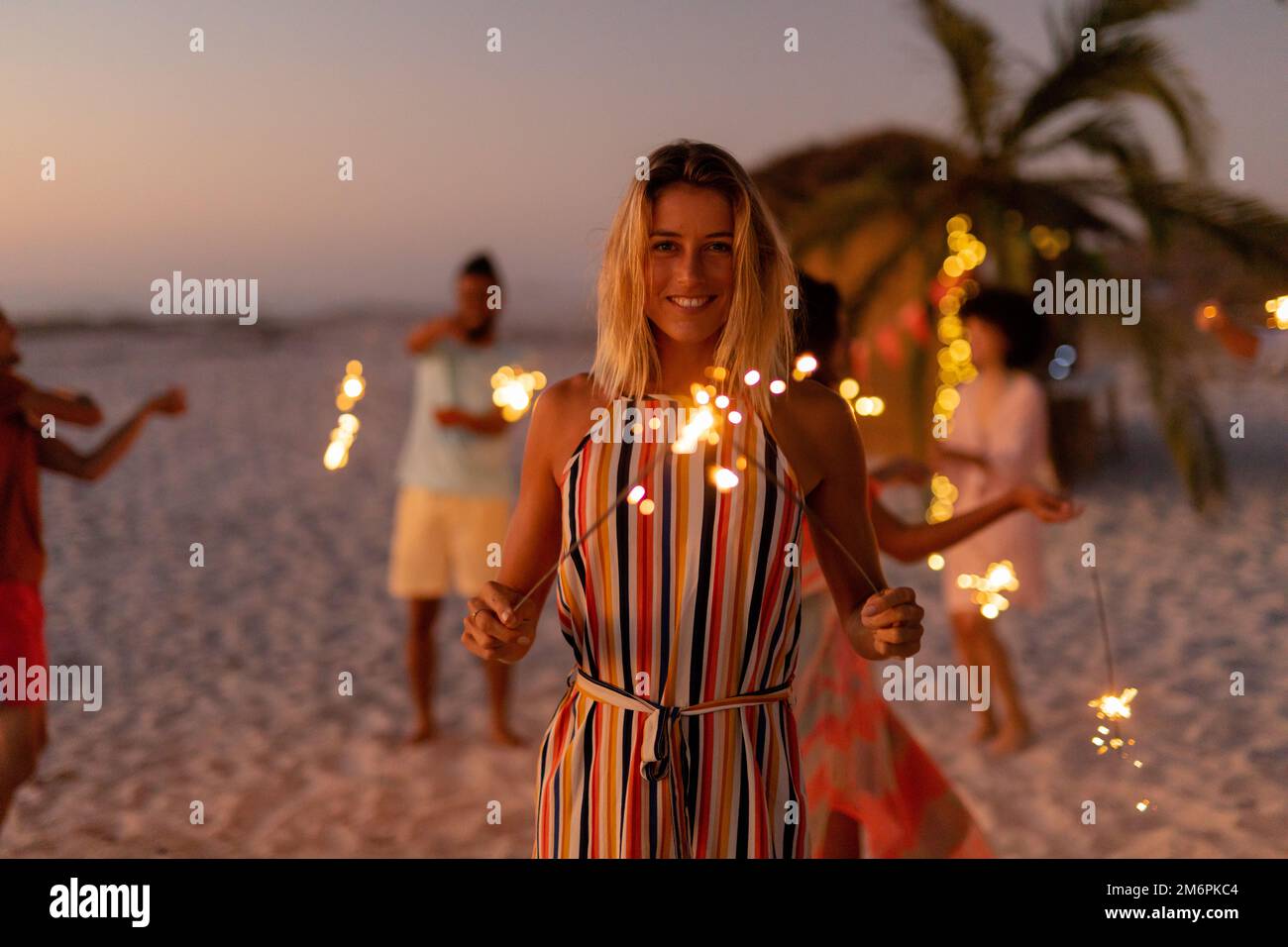 Multi-ethnic group of male and female dancing with firework stick Stock ...