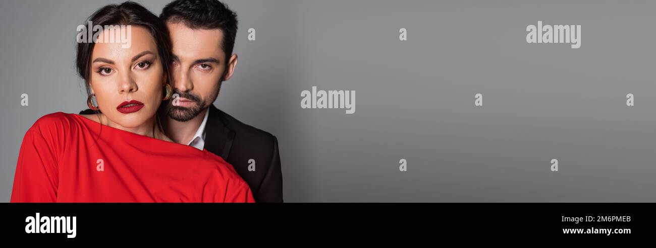 Elegant woman with burgundy lips looking at camera near boyfriend on ...