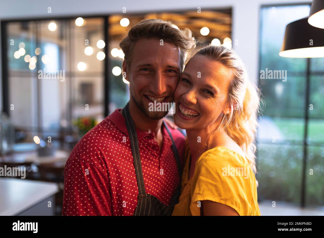 Caucasian couple spending time in the kitchen and cuddling Stock Photo ...