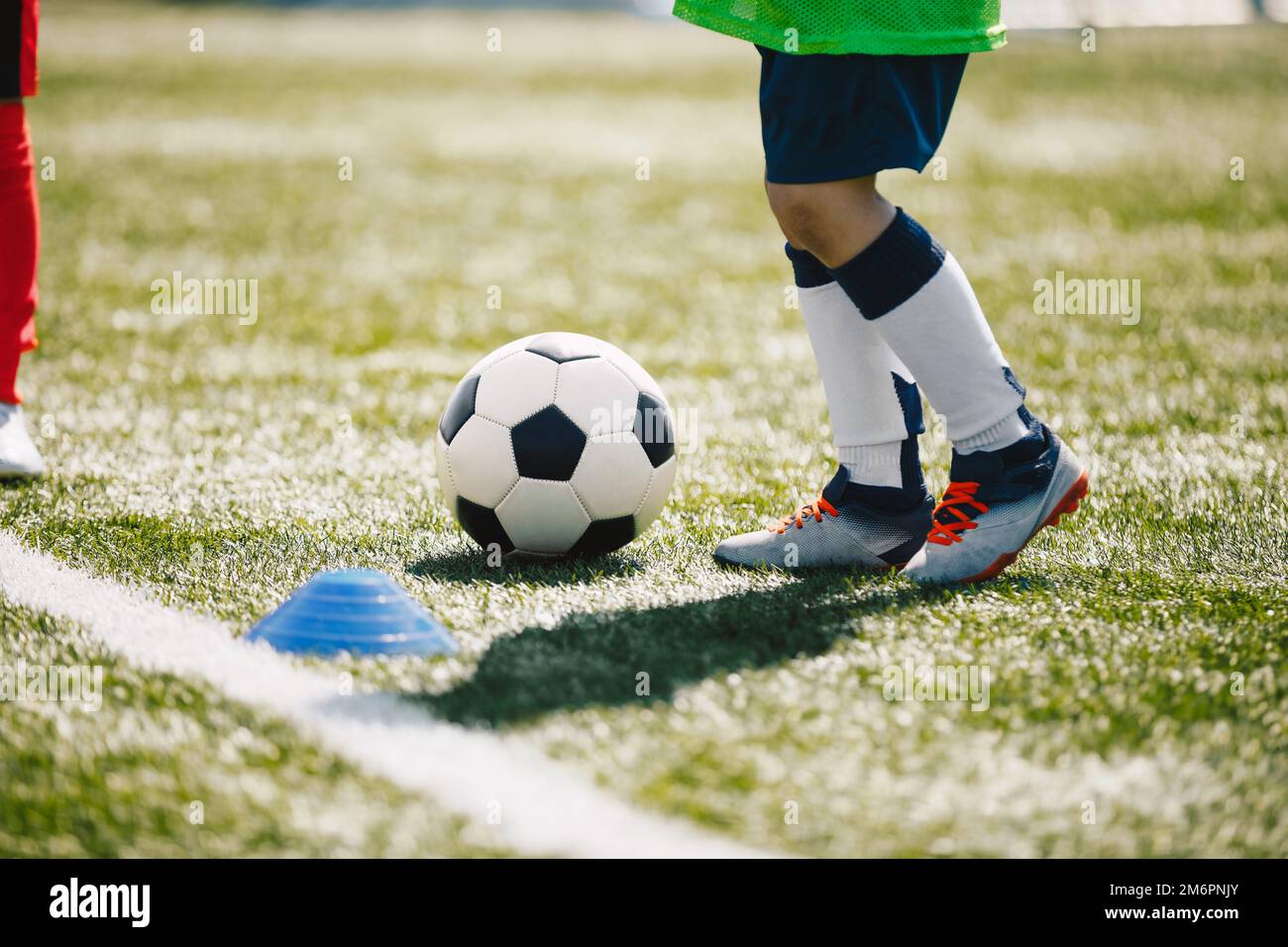 Little boy running and kicking classic soccer ball on training class ...