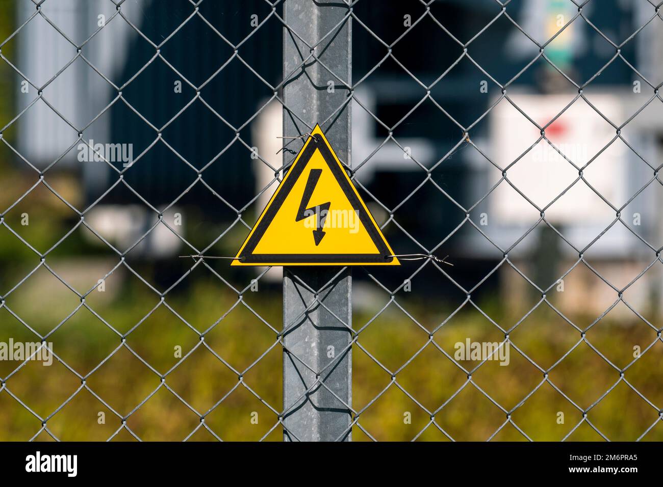Yellow triangle with lightning on metal fence Stock Photo - Alamy