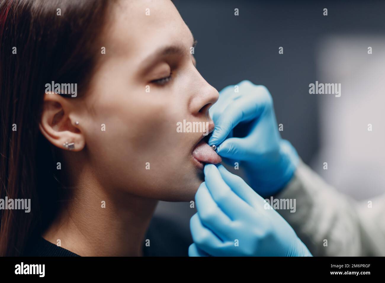 Young woman doing tonque piercing at beauty studio salon Stock Photo ...