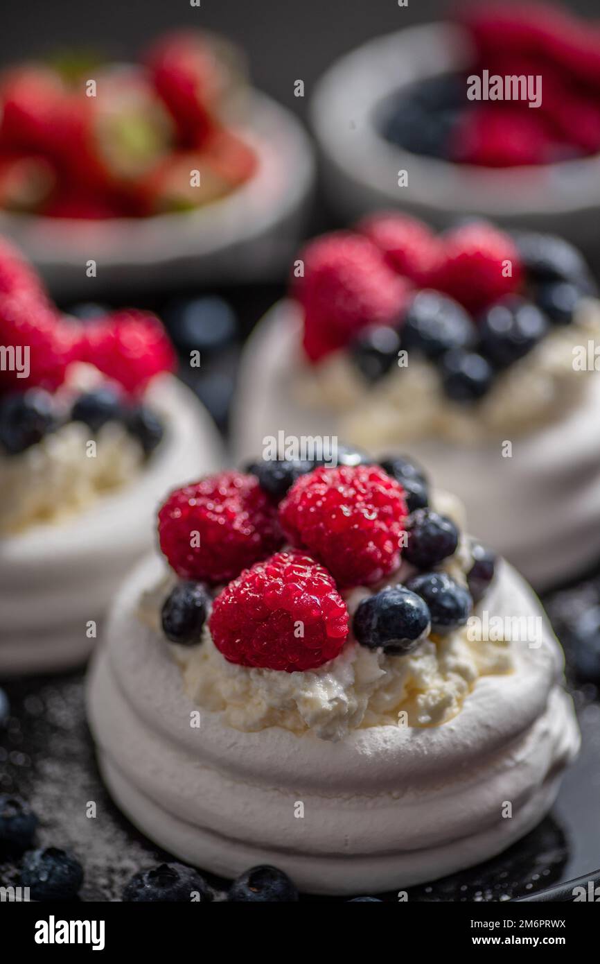 Mini Pavlova cakes topped with berries and mascarpone cheese Stock ...