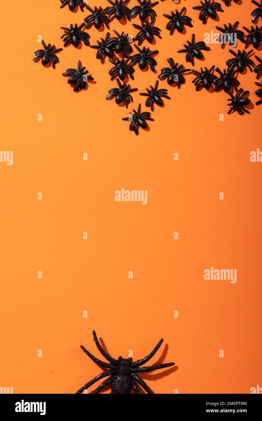 Close up of multiple spider toys with copy space against orange ...