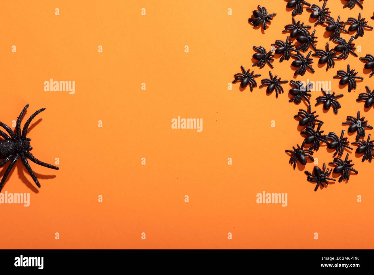 Close up of multiple spider toys with copy space against orange ...