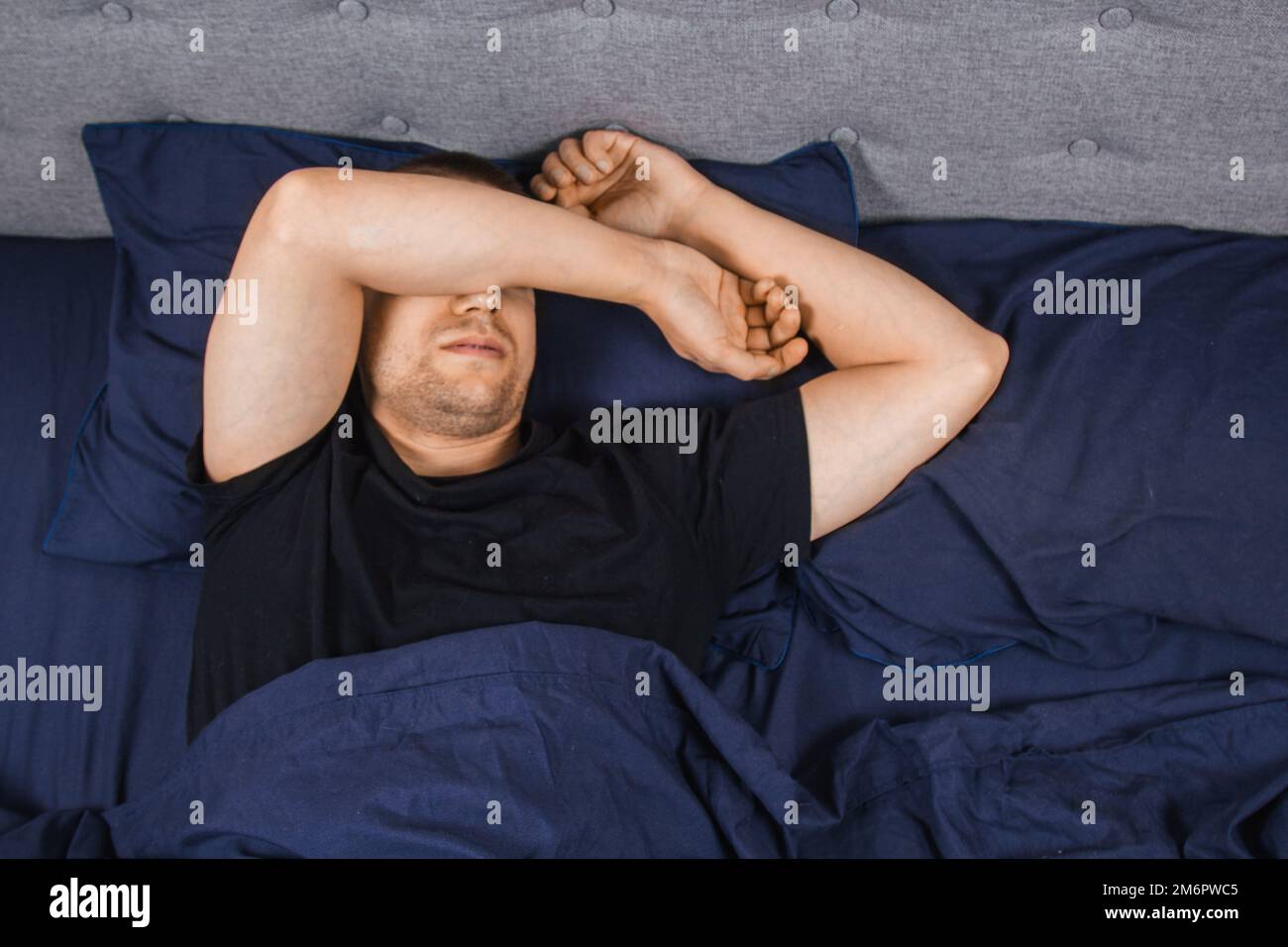 Top view of a handsome young man sleeping comfortably on the bed in his ...