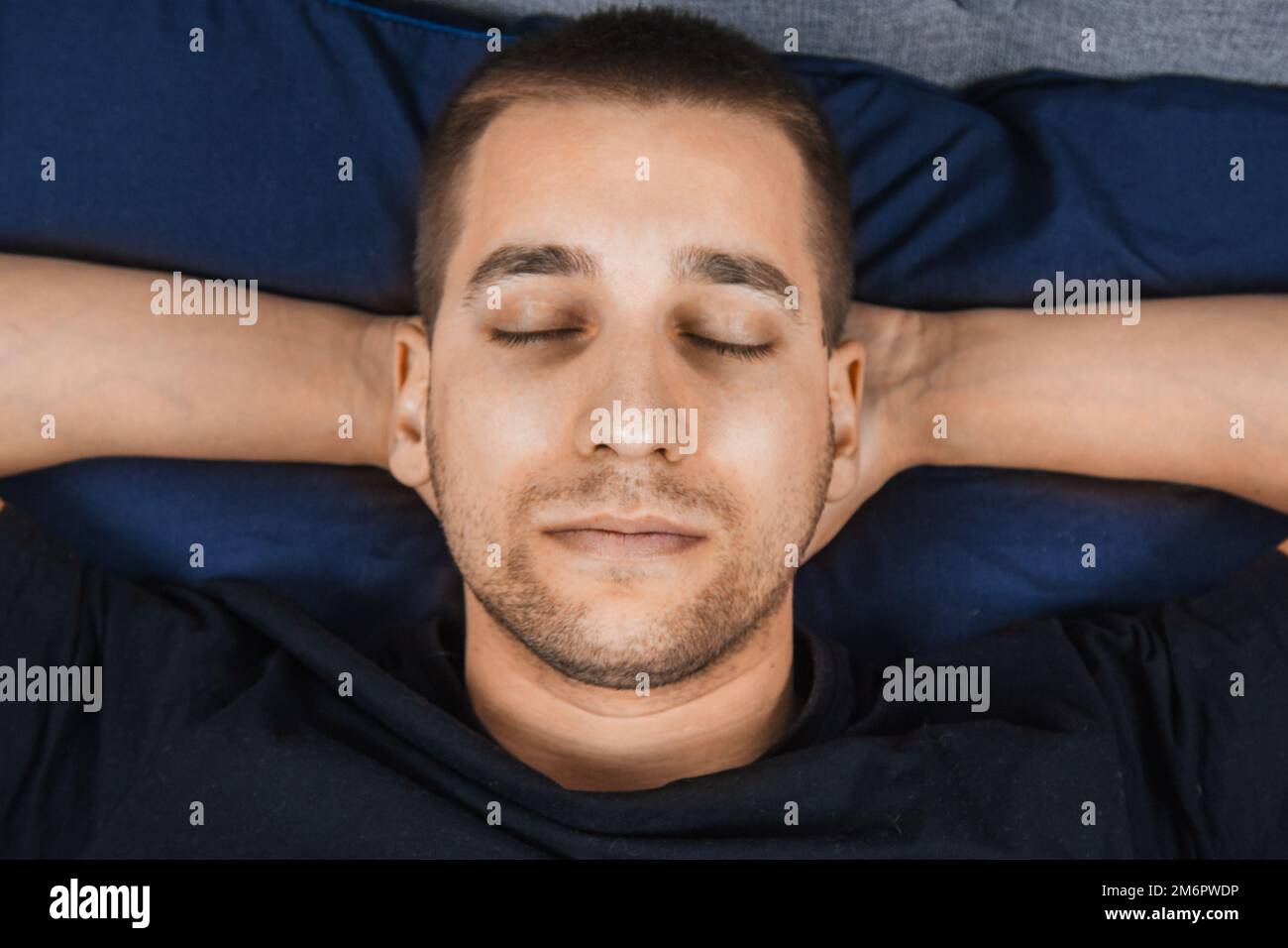 Top View Of A Handsome Young Man Sleeping Comfortably On The Bed In His