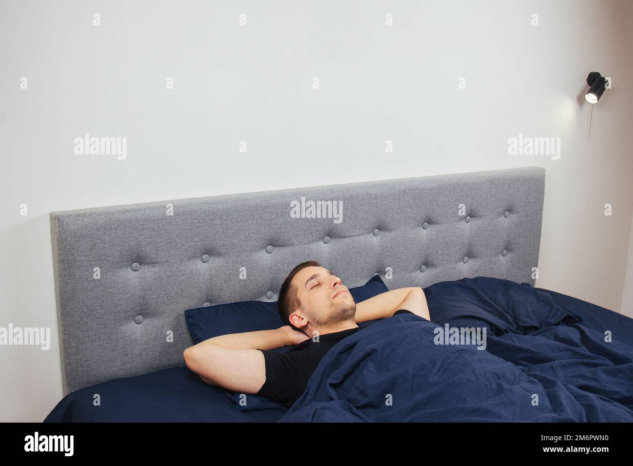 Top view of a handsome young man sleeping comfortably on the bed at ...