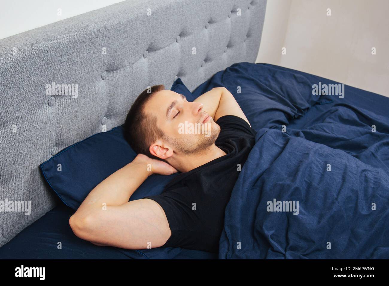 Top view of a handsome young man sleeping comfortably on the bed at ...