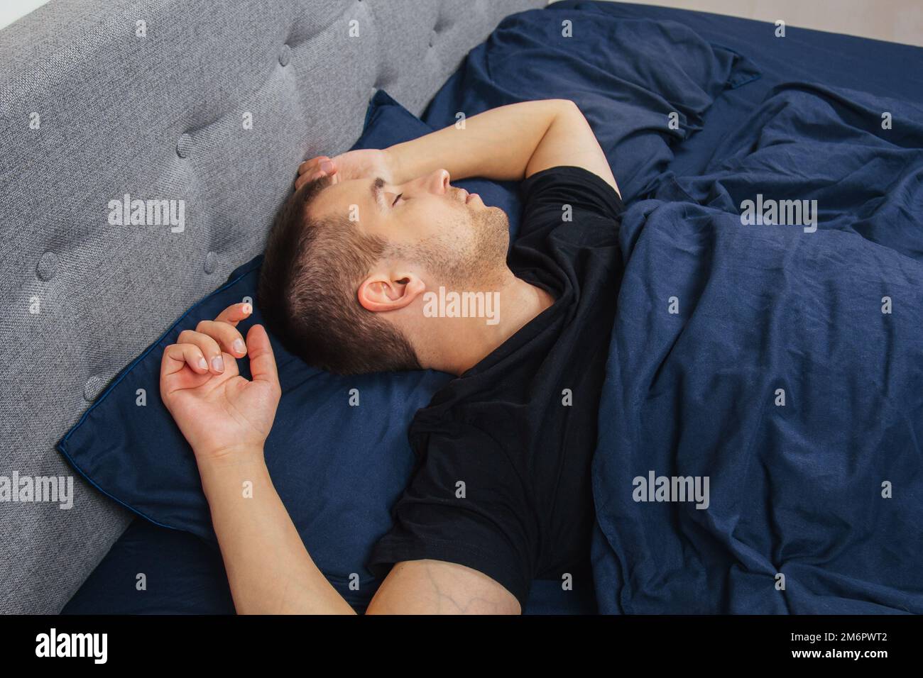Top view of a handsome young man sleeping comfortably on the bed at ...