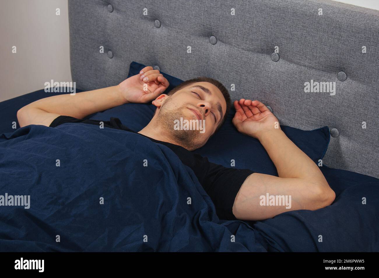 Top view of a handsome young man sleeping comfortably on the bed at ...