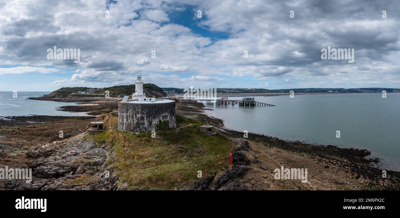View of the Mumbles headland with the historic lighthouse and piers in ...