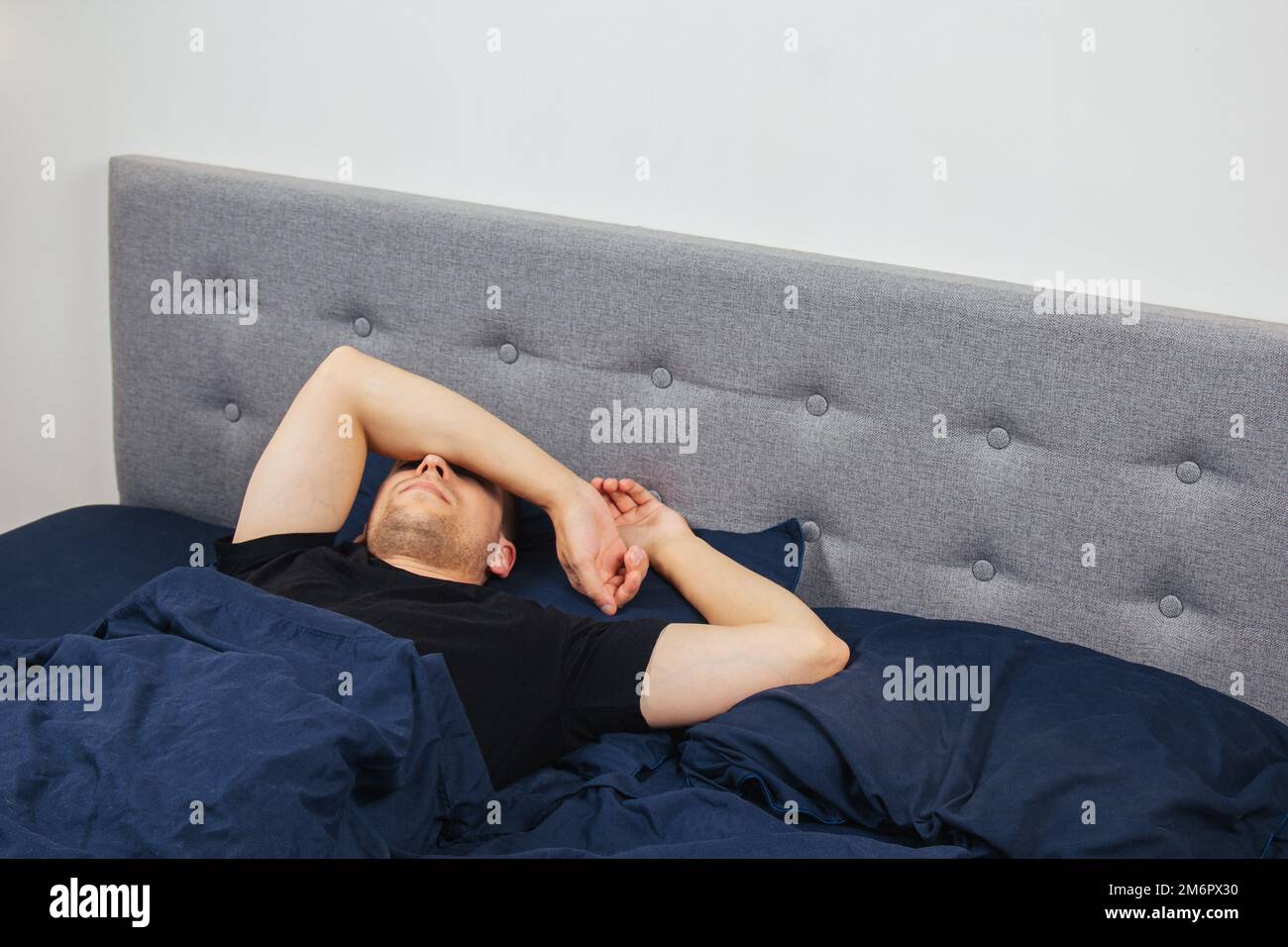 Top view of a handsome young man sleeping comfortably on the bed at ...
