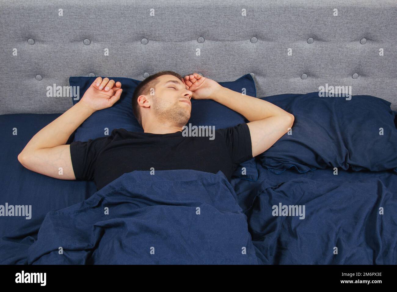 Top view of a handsome young man sleeping comfortably on the bed at ...