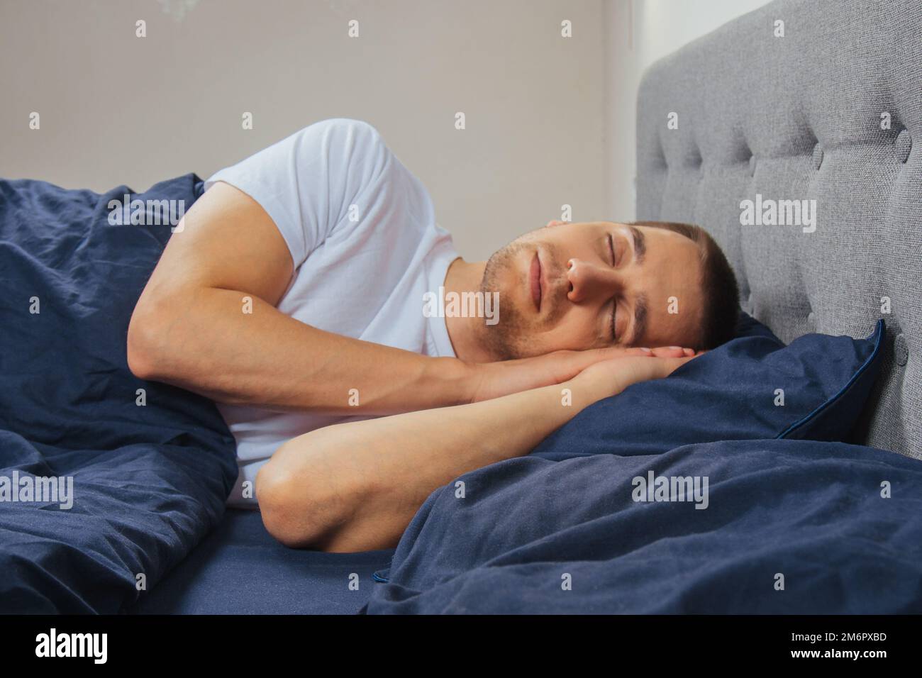 Top view of a handsome young man sleeping comfortably on the bed at ...