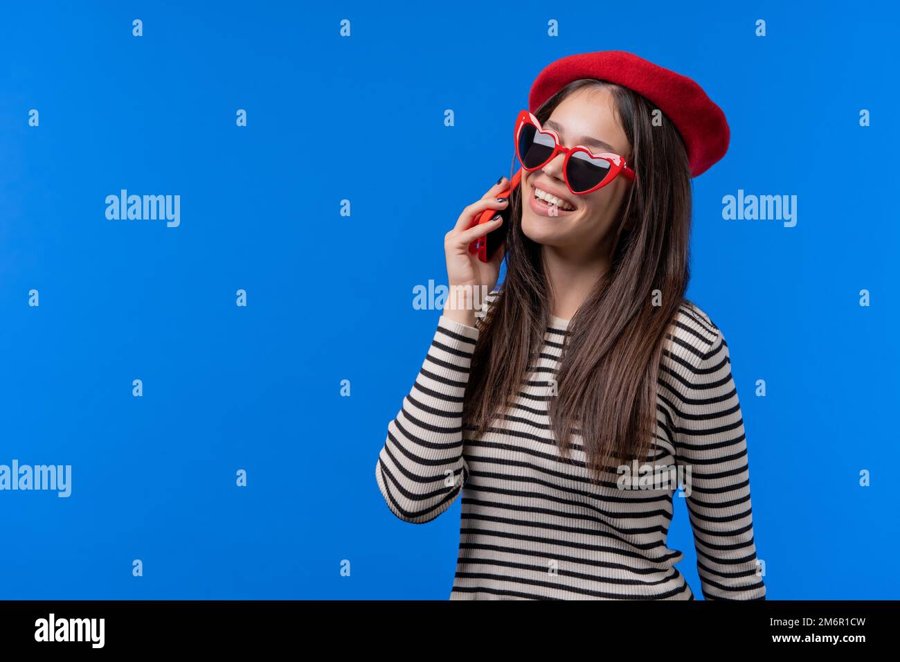 Stylish french woman talking by phone, nice joke, smiling. Young lady ...