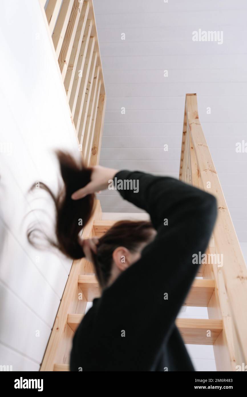 Young woman simple hairstyle against wooden stairs. Depression ...
