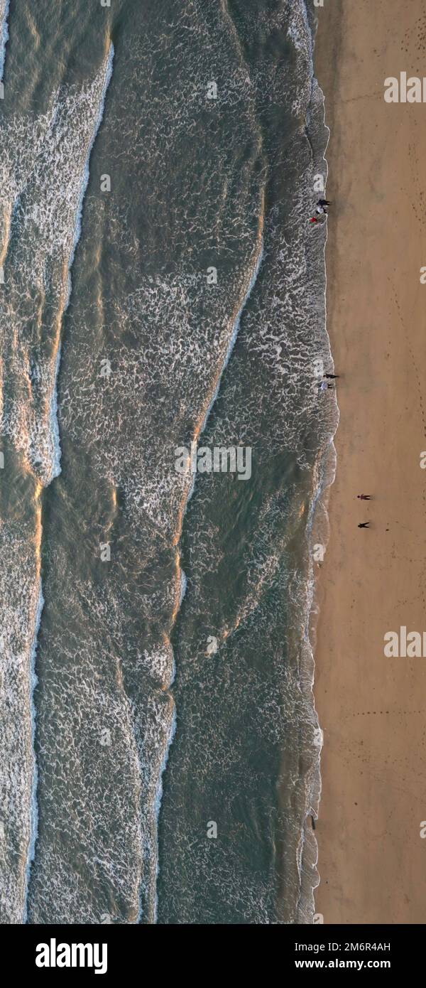 An aerial vertical shot of sea waves flowing to the sandy beach Stock ...