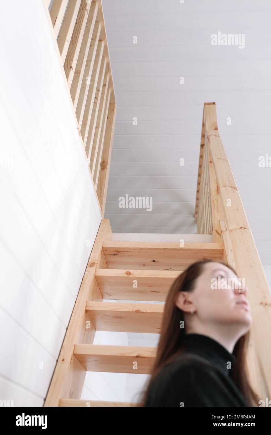 Young woman simple hairstyle against wooden stairs. Depression ...