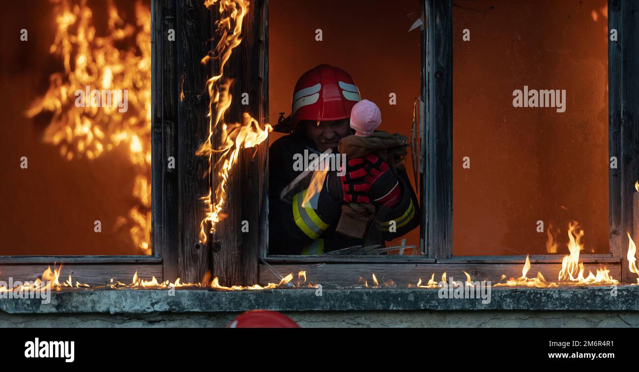 Firefighter hero carrying baby girl out from burning building area from ...